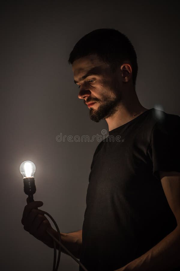 The Man With The Light Bulb On Black Background Stock Photo - Image of ...