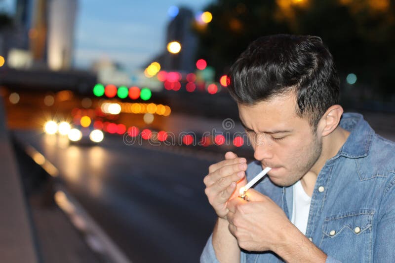 Man Lighting a Cigarette in the City Streets at Night Stock Image ...