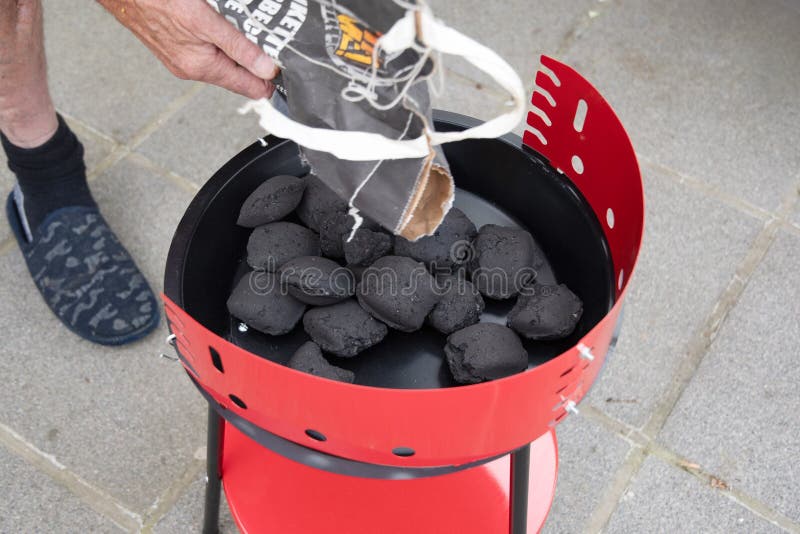 A Man Lights a Fire with a Lighter Special Charcoals for a Barbecue ...