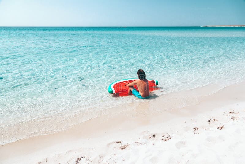 Man on lilo on the beach stock photo. Image of vacation - 112556218