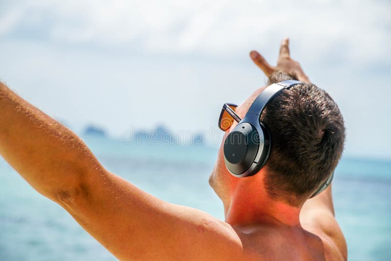 Man Listen Music in Headphones on the Beach Stock Image - Image of ...