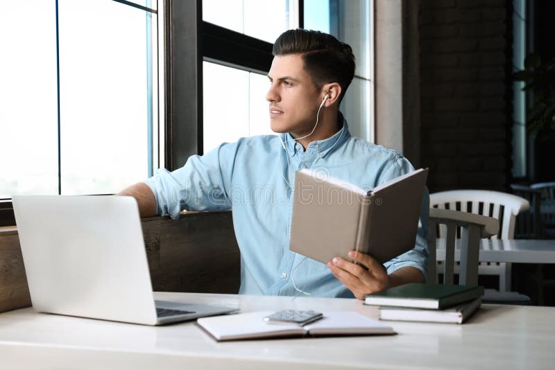 Man Listening To Audiobook at Table in Cafe Stock Photo - Image of ...