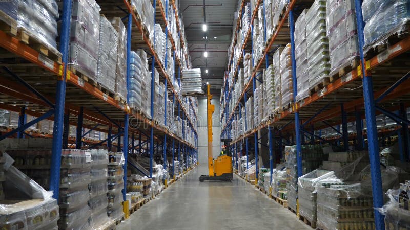 Man on the Loader in the Warehouse Lifts the Container from the First ...