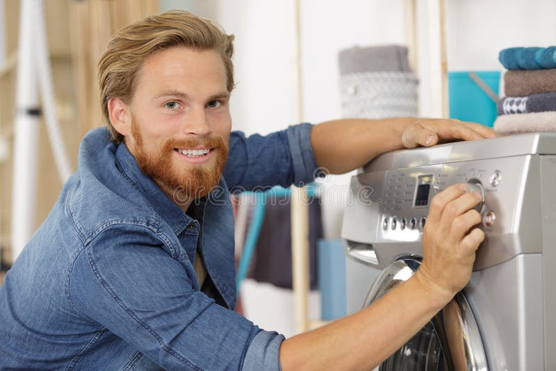 Man Loading Clothes into Washing Machine in Kitchen Stock Photo - Image ...