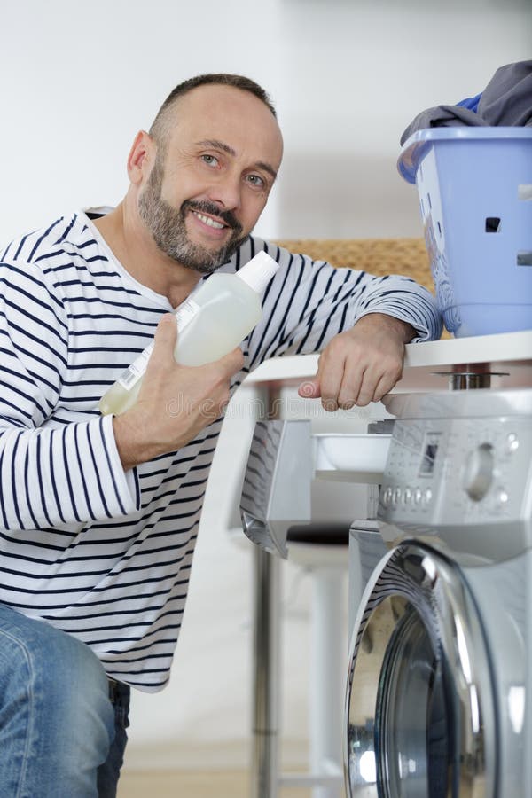 Man Loading Clothes into Washing Machine in Kitchen Stock Photo - Image ...