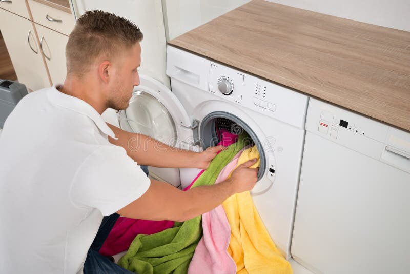 Man Loading Towels into the Washing Machine Stock Image - Image of ...