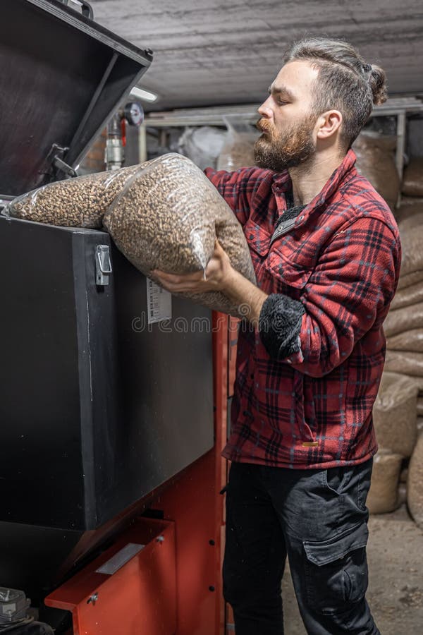 The Man Loads the Pellets in the Solid Fuel Boiler, Working with ...