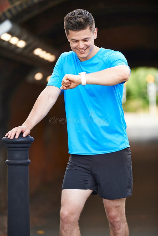 Man Looking at Activity Tracker Whilst Exercising in Urban Setting ...