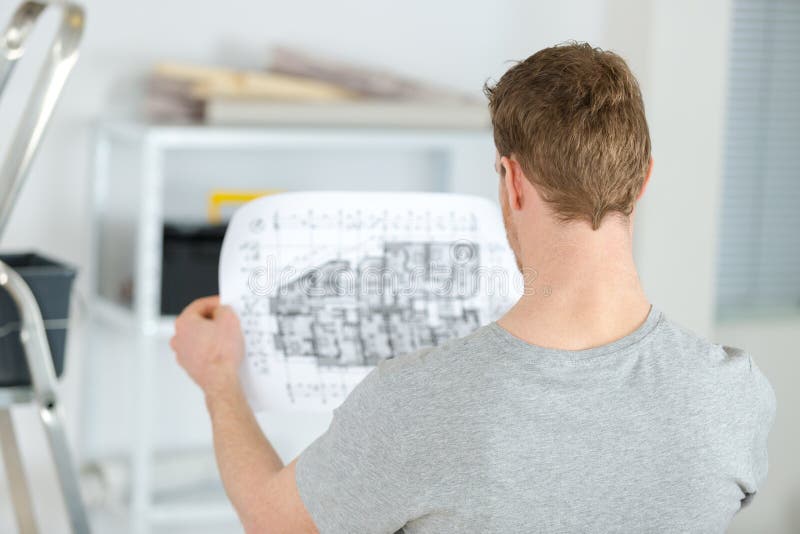 Man looking at blueprint stock photo. Image of document - 186437796