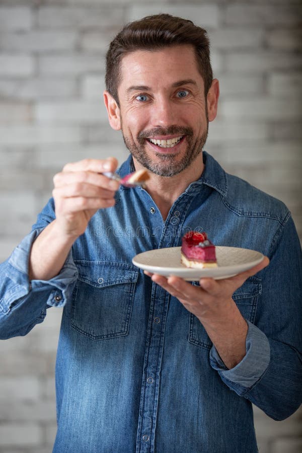Man Looking at Camera Offering Cake Stock Photo - Image of hair ...