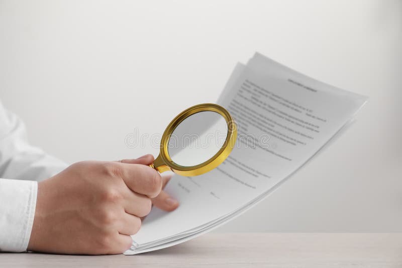 Man Looking at Document through Magnifier at White Wooden Table ...