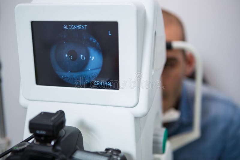 Man Looking at Eye Test Machine Stock Photo - Image of male ...