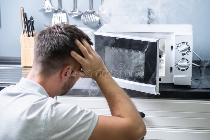 Man Looking at Fire Coming from Microwave Oven Stock Photo - Image of ...