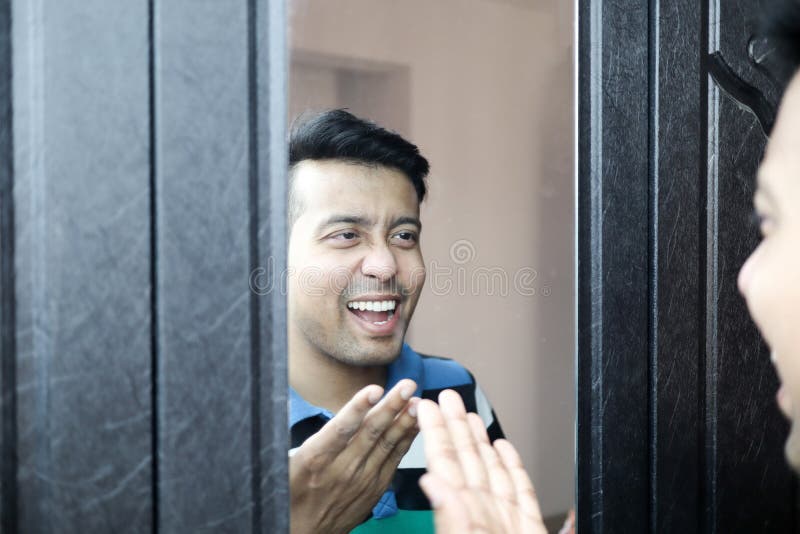 A Man Looking at His Reflection in Mirror and Laughing at Himself Stock ...