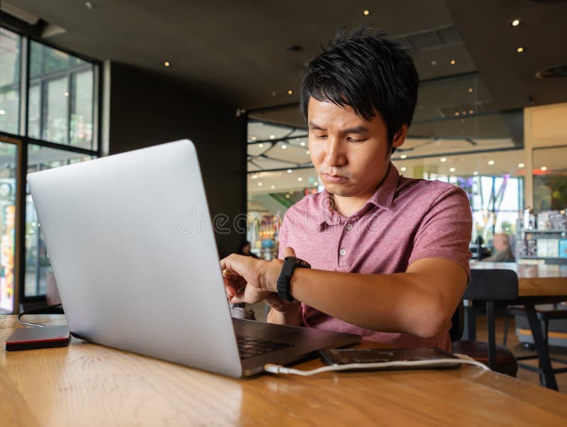 Man is Looking His Smart Watch with Laptop Computer in Cafe Stock Image ...
