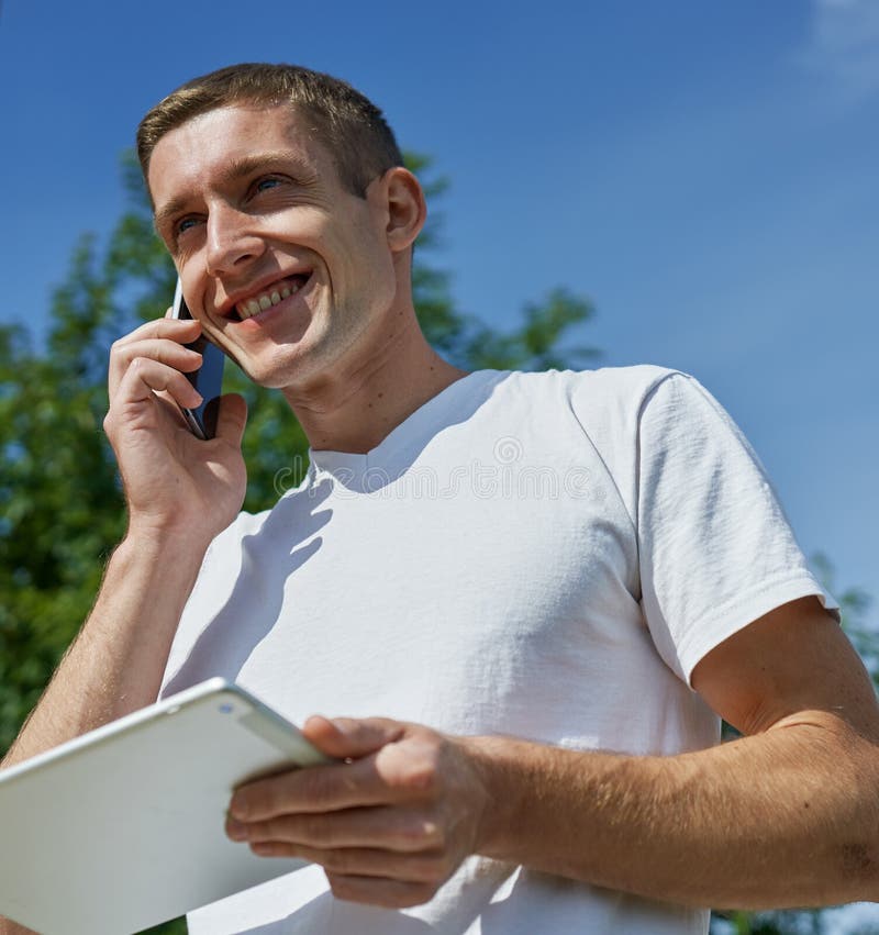 Man Looking at His Tablet Someone is Calling on the Phone Stock Photo ...