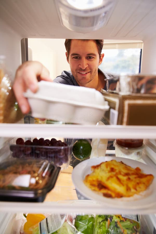 Man Looking Inside Fridge Full of Food and Choosing Apple Stock Photo ...