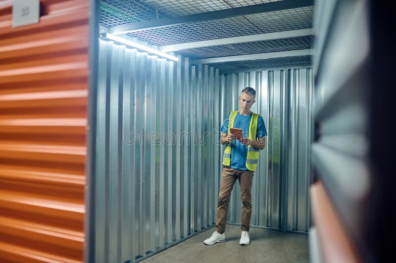 Man Looking Intently at Work Tablet in Garage Stock Image - Image of ...