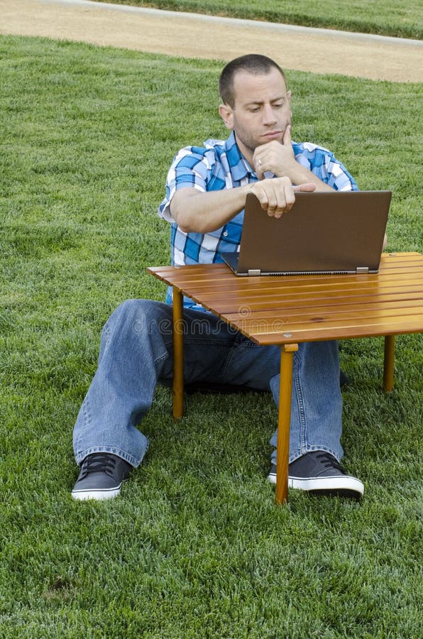 Man Looking at a Laptop Outdoors. Stock Image - Image of table, next ...