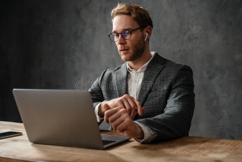 A Man Looking into a Laptop Screen while Sitting at a Table in the ...