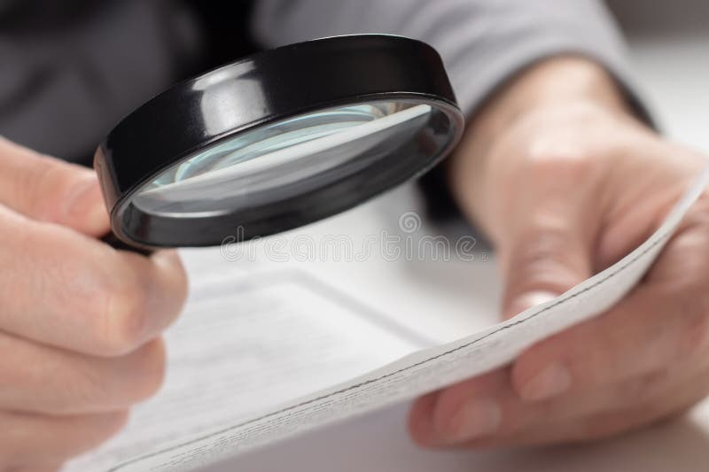 Man Looking through a Magnifying Glass To Documents Stock Image - Image ...