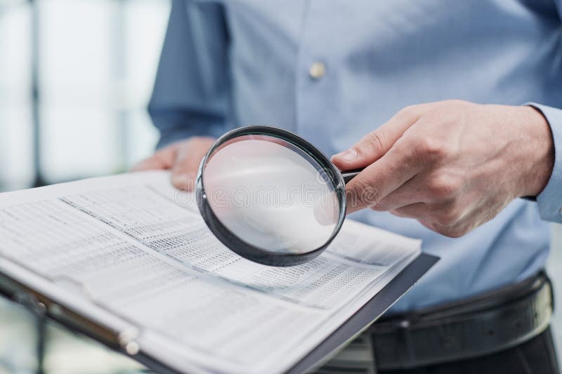 Businessman Looking through a Magnifying Glass To Documents Stock Image ...