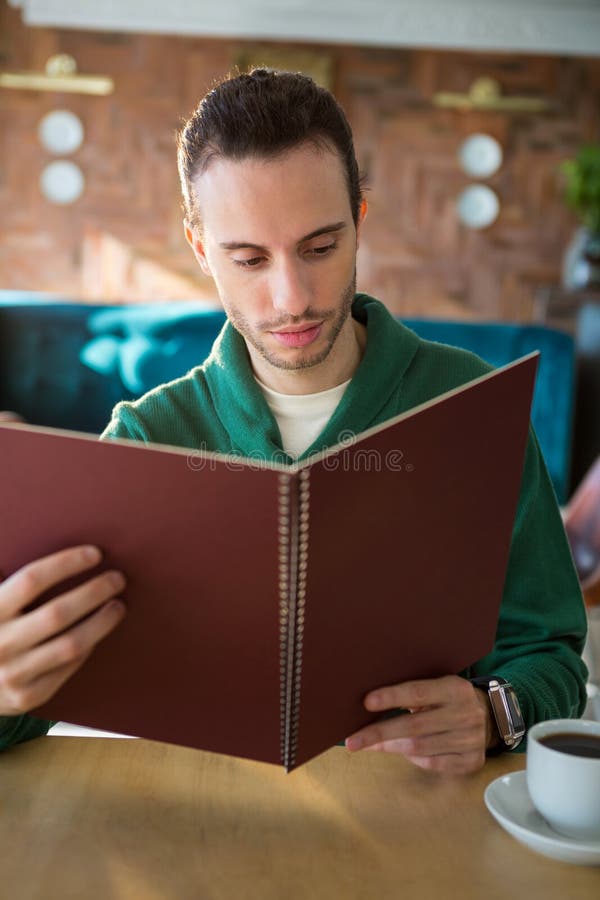 Man Looking at Menu in Restaurant Stock Image - Image of female ...