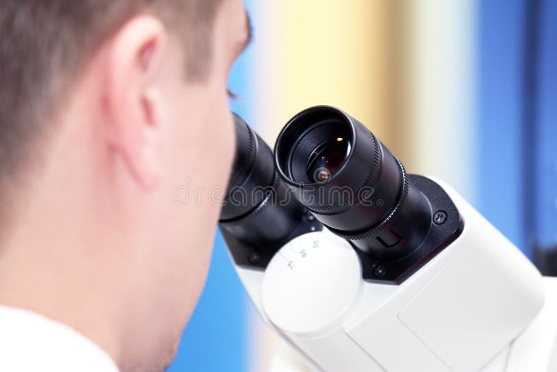 Man Looking through a Microscope Closeup. Research in Pharmacology and ...