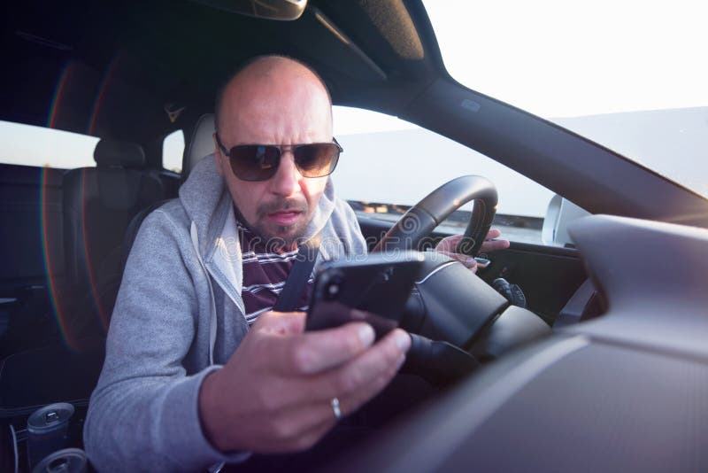 Man Looking at Mobile Phone while Driving a Car Stock Photo - Image of ...