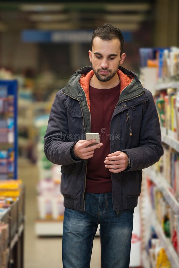 Man Looking at Mobile Phone in Shopping Centre Stock Image - Image of ...