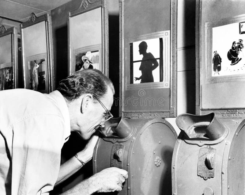 Man Looking into a Nickelodeon Film Machine Stock Photo - Image of ...
