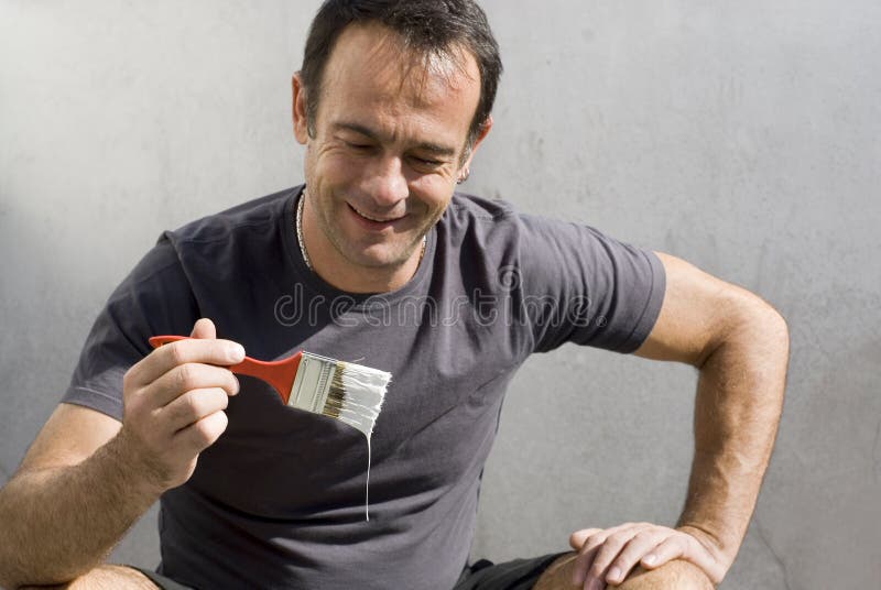 Man Looking at Paint on Brush - Horizontal Stock Image - Image of ...