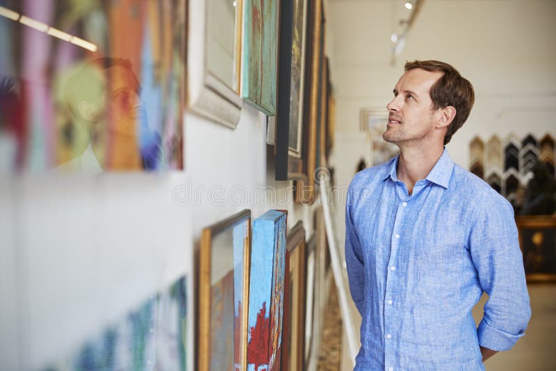 Man Looking at Paintings in Art Gallery Stock Image - Image of relaxed ...