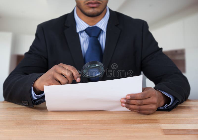 Man Looking at Paper with Magnifying Glass at Desk Stock Image - Image ...