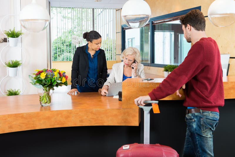 Man Looking at Receptionists in Hotel Stock Image - Image of desk ...
