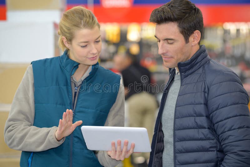 Man Looking and Salesman Using Tablet Computer in Store Stock Photo ...