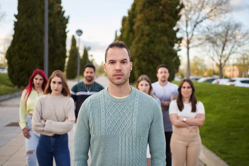 Man Looking Serious at the Camera while Standing in Front of a Group of ...
