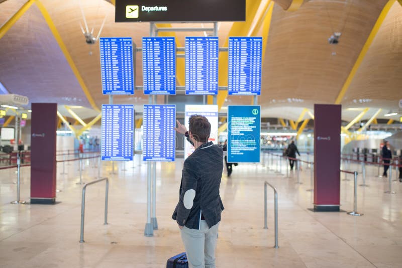 Man Looking at the Timetable Information Panel in the Airport Wi Stock ...