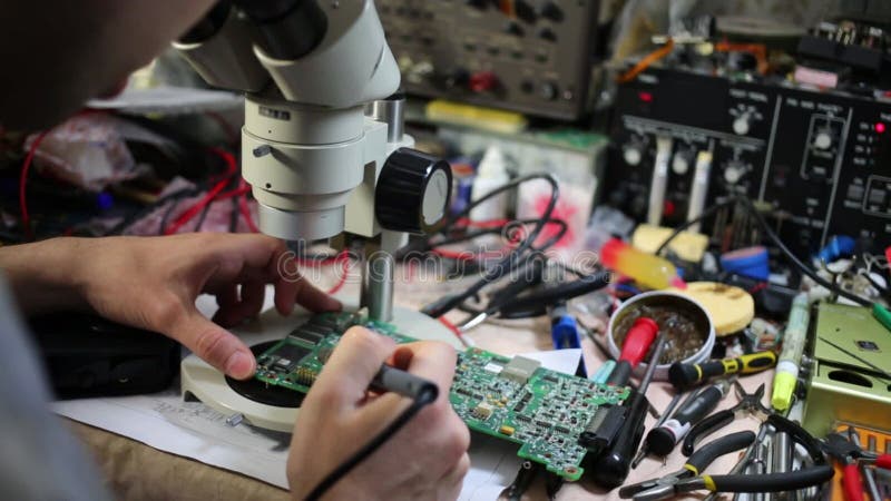 Man Looks at Motherboard through Microscope and Stock Video - Video of ...