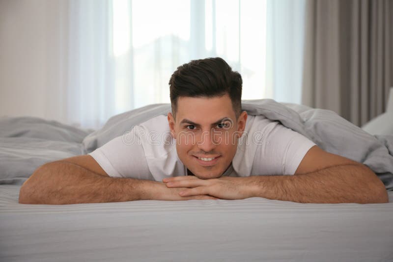 Man Lying in Bed with Grey Linens Stock Photo - Image of bedding, lying ...