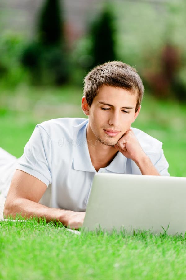 Man Lying on the Grass Works at the Computer Stock Photo - Image of ...