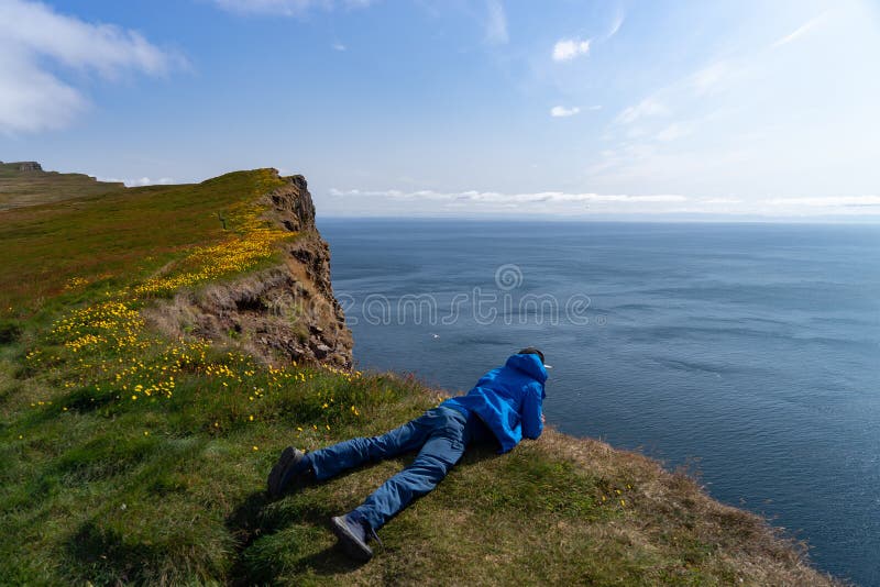 The Man Lying on Latrabjarg Cliff and Looking Down Stock Image - Image ...