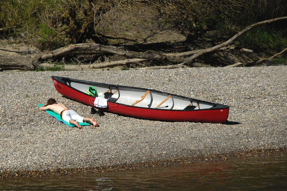 Man Lying Next to Canoe stock photo. Image of river, land - 2225550