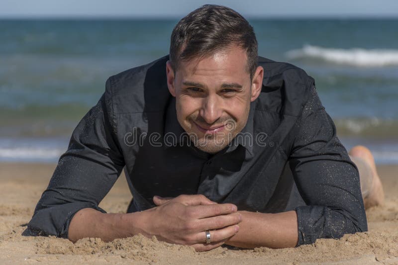 Man Lying on the Beach Sand Taking Off His Sunglasses Stock Image ...