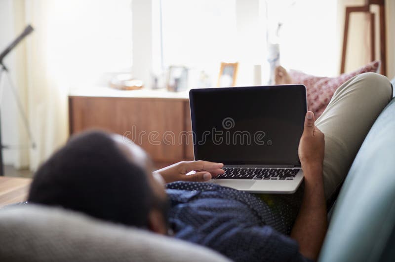 Man Lying on Sofa at Home Using Laptop Computer Stock Image - Image of ...