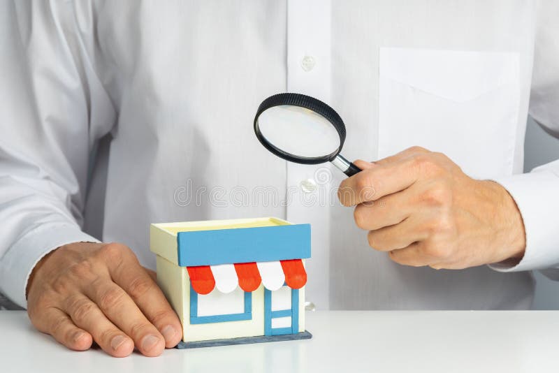 Man with a Magnifying Glass Examines the Store. Business Audit or ...