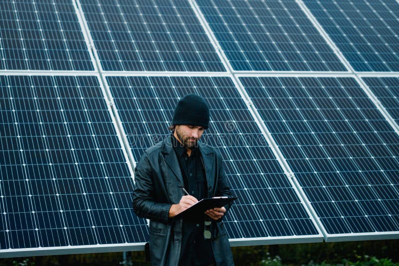 Man Make Notes into Clipboard beside of Solar Panels Stock Photo ...