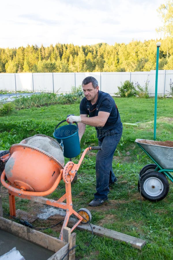 A Man Makes a Blind Area Near the House in the Country. Stock Photo ...