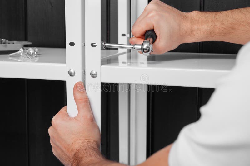 A Man Makes a Bond between Two White Metal Shelves Stock Photo - Image ...