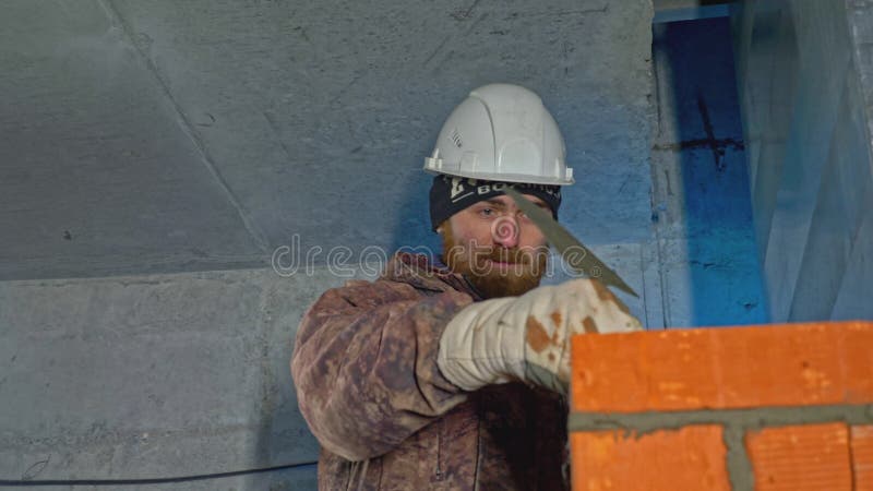 Man Makes Brickwork at Construction Site. Clip. Uniformed Worker Makes ...